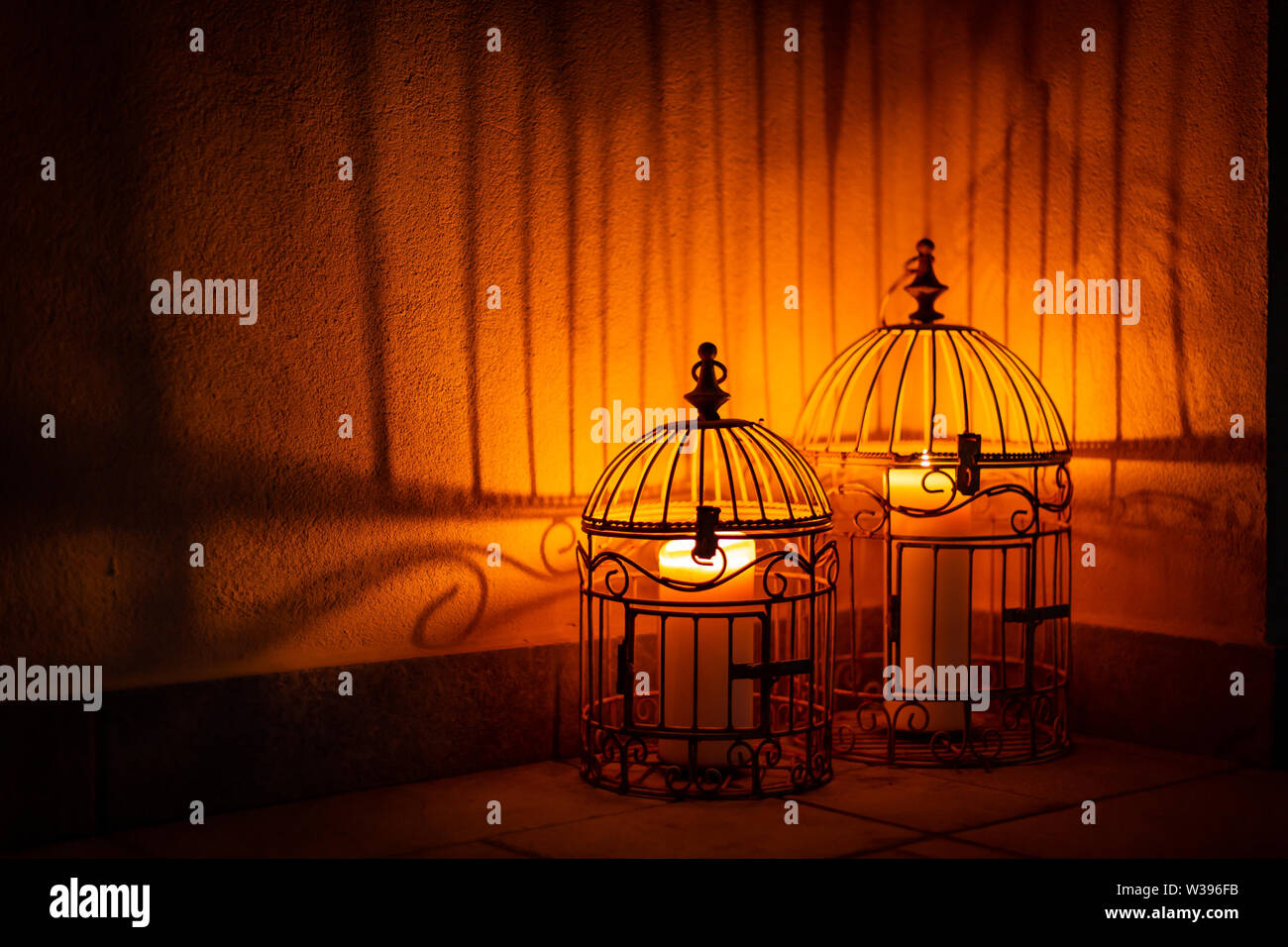 Caged candle lights with shadows on the wall Stock Photo - Alamy