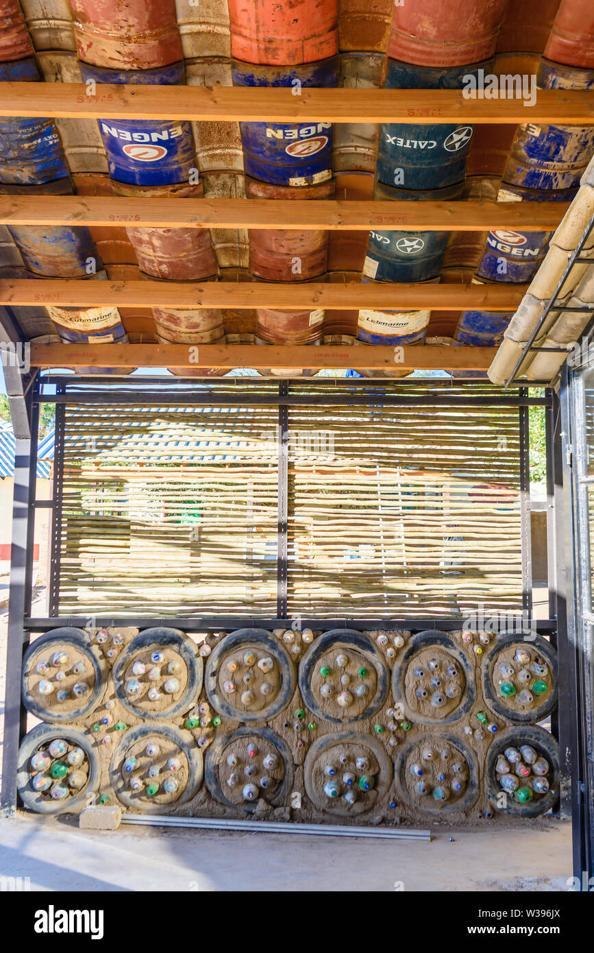 Wall made from old tyres and wooden branches, and a roof made from oil ...