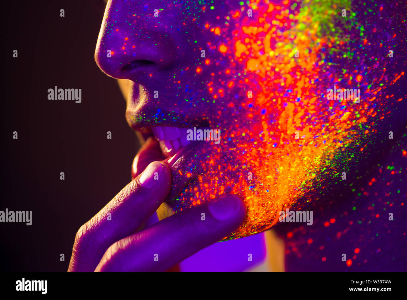 Portrait of fashionable man with colored fluo painting on the face ...