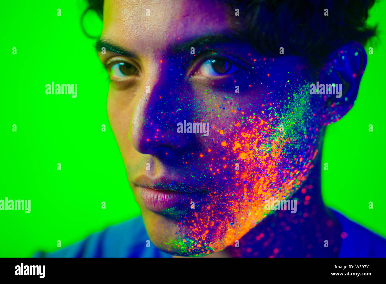 Portrait of fashionable man with colored fluo painting on the face ...