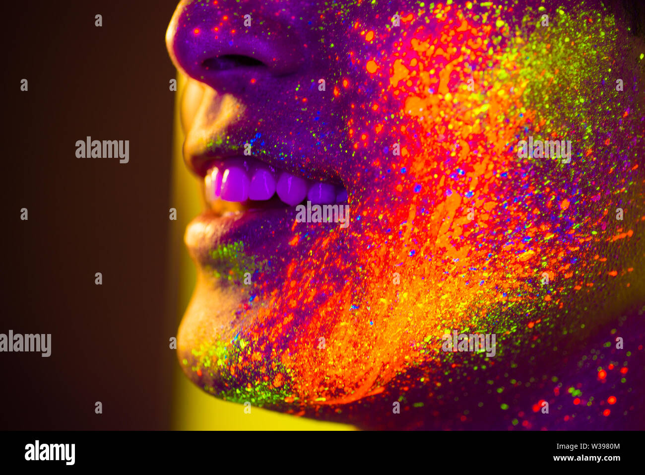 Portrait of fashionable man with colored fluo painting on the face ...