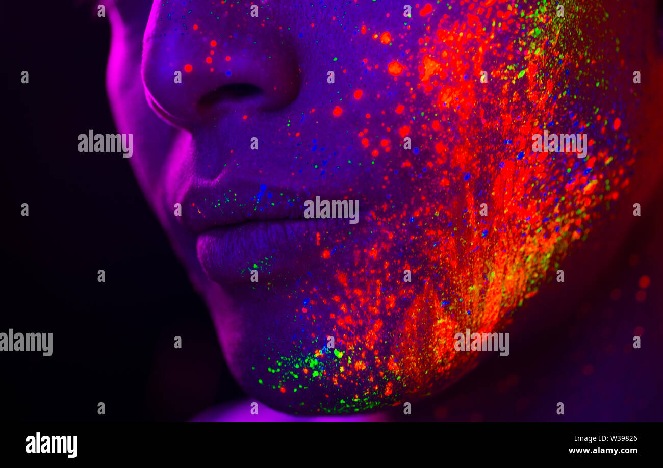Portrait of fashionable man with colored fluo painting on the face ...