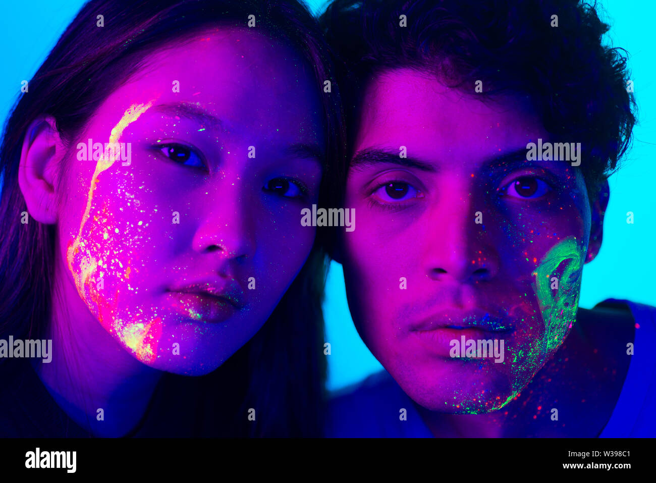 Portrait of fashionable man with colored fluo painting on the face ...