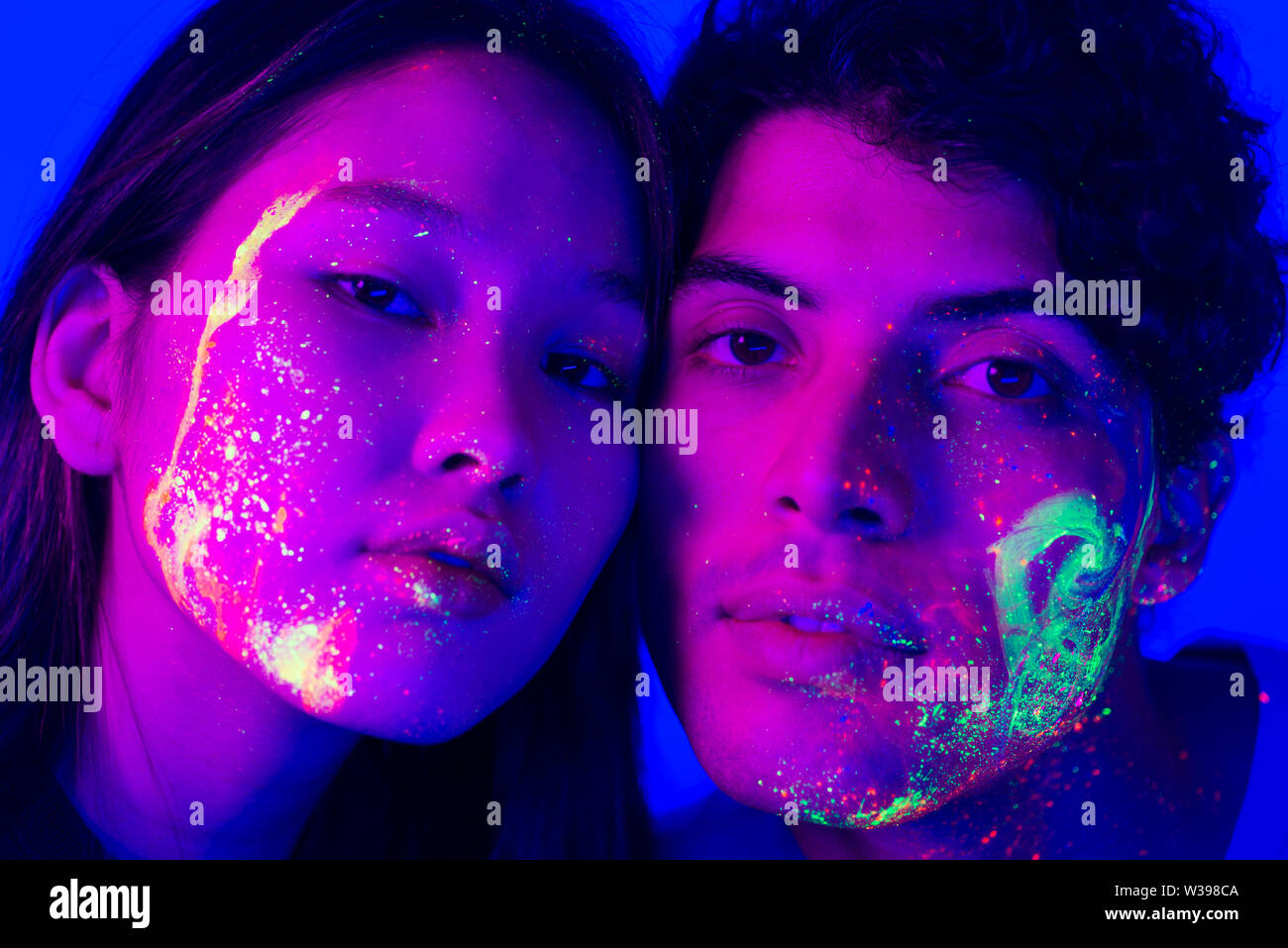 Portrait of fashionable man with colored fluo painting on the face ...