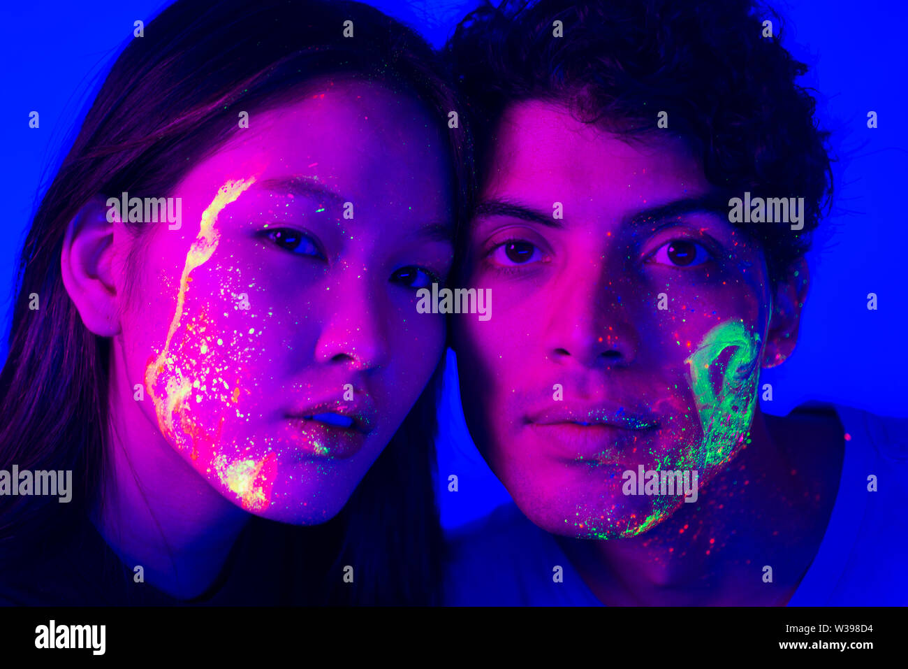 Portrait of fashionable man with colored fluo painting on the face ...