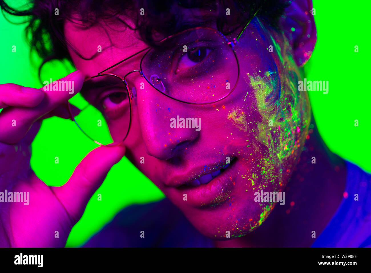 Portrait of fashionable man with colored fluo painting on the face ...