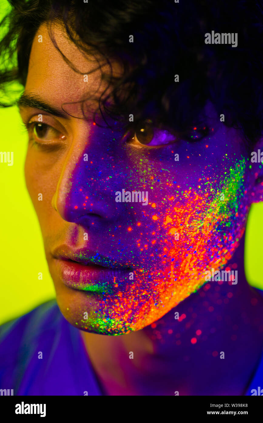 Portrait of fashionable man with colored fluo painting on the face ...