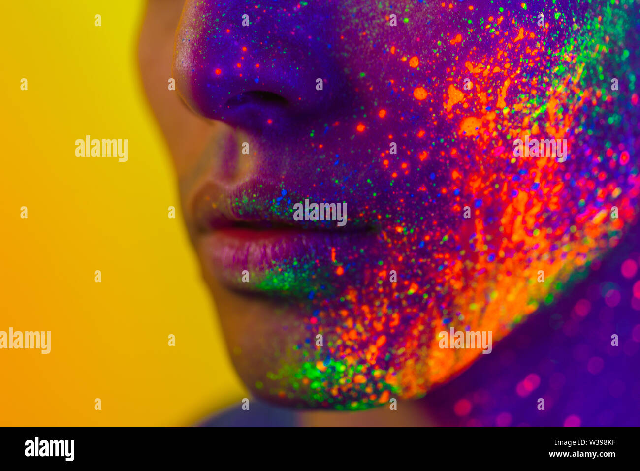 Portrait of fashionable man with colored fluo painting on the face ...