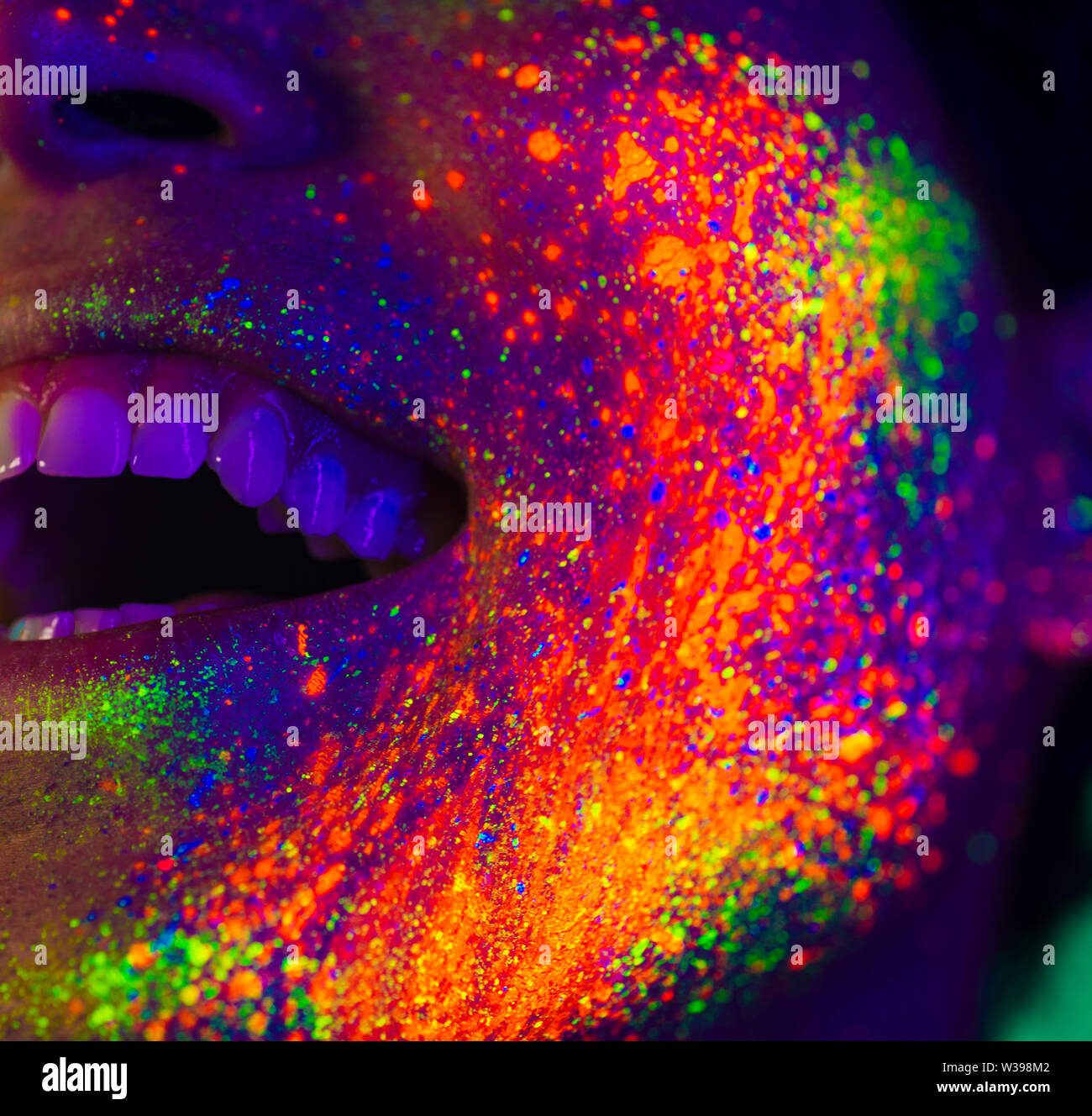 Portrait of fashionable man with colored fluo painting on the face ...