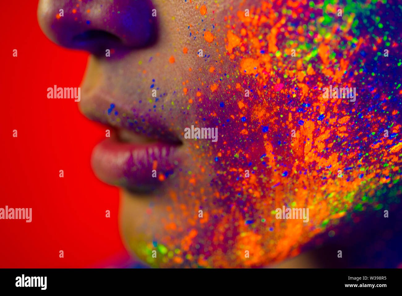 Portrait of fashionable man with colored fluo painting on the face ...