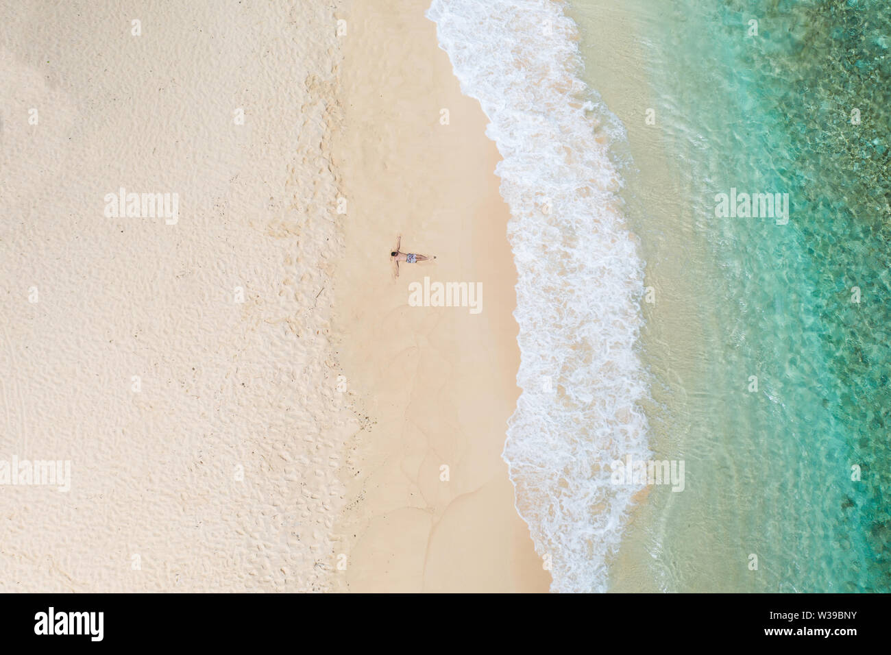 Man wearing swimwear and tropical shirt on a beautiful sandy tropical ...