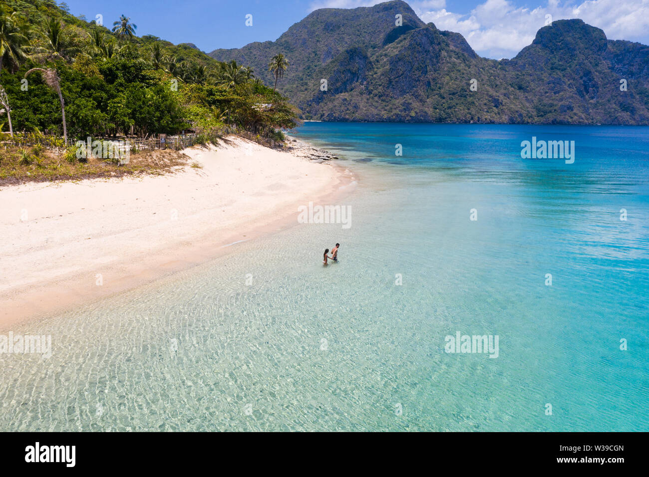 Tropical beach with blue water and palm trees - El Nido, Palawan ...