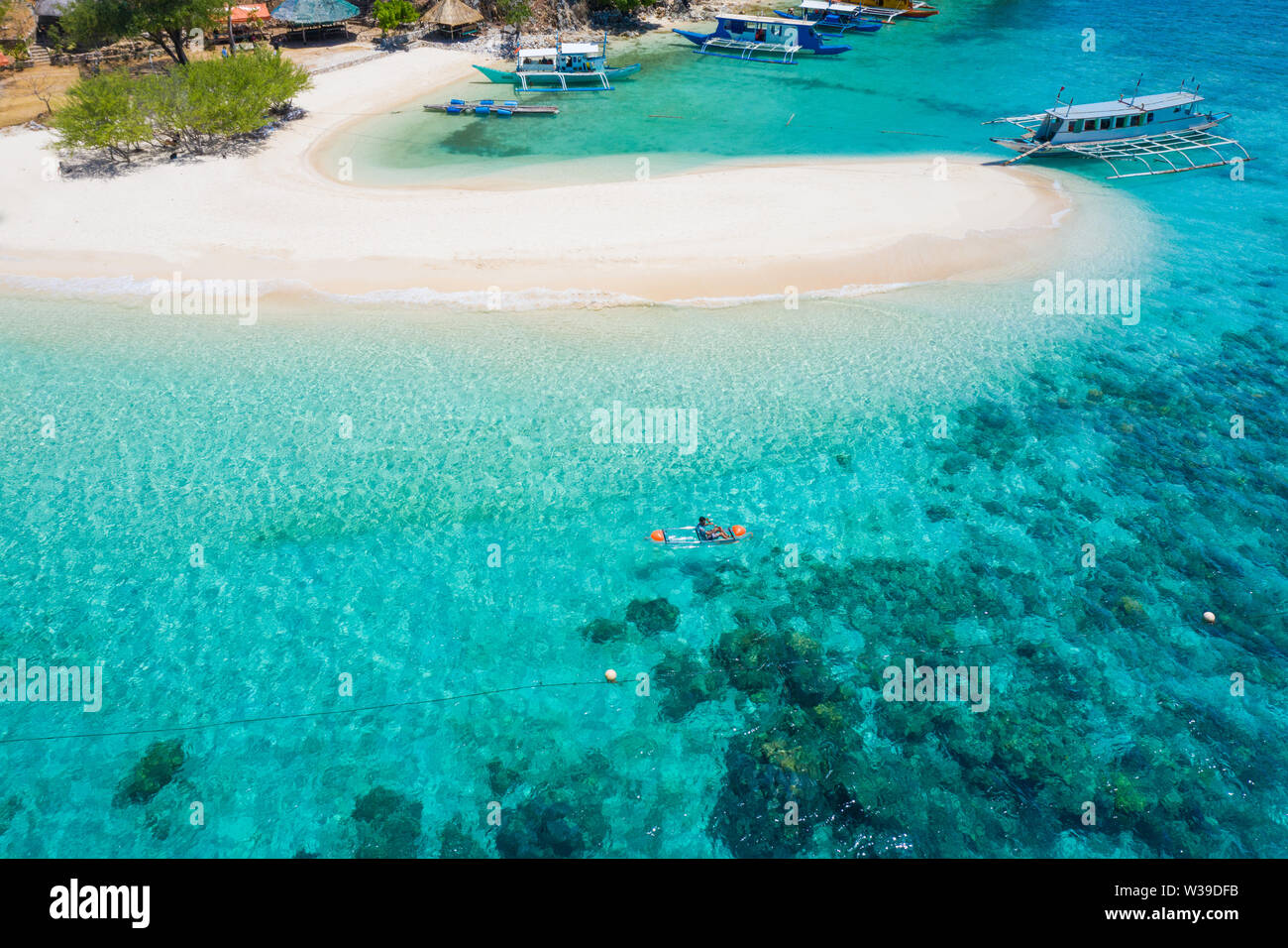 Tourist on a tropical beach with blue water and palm trees - Coron ...