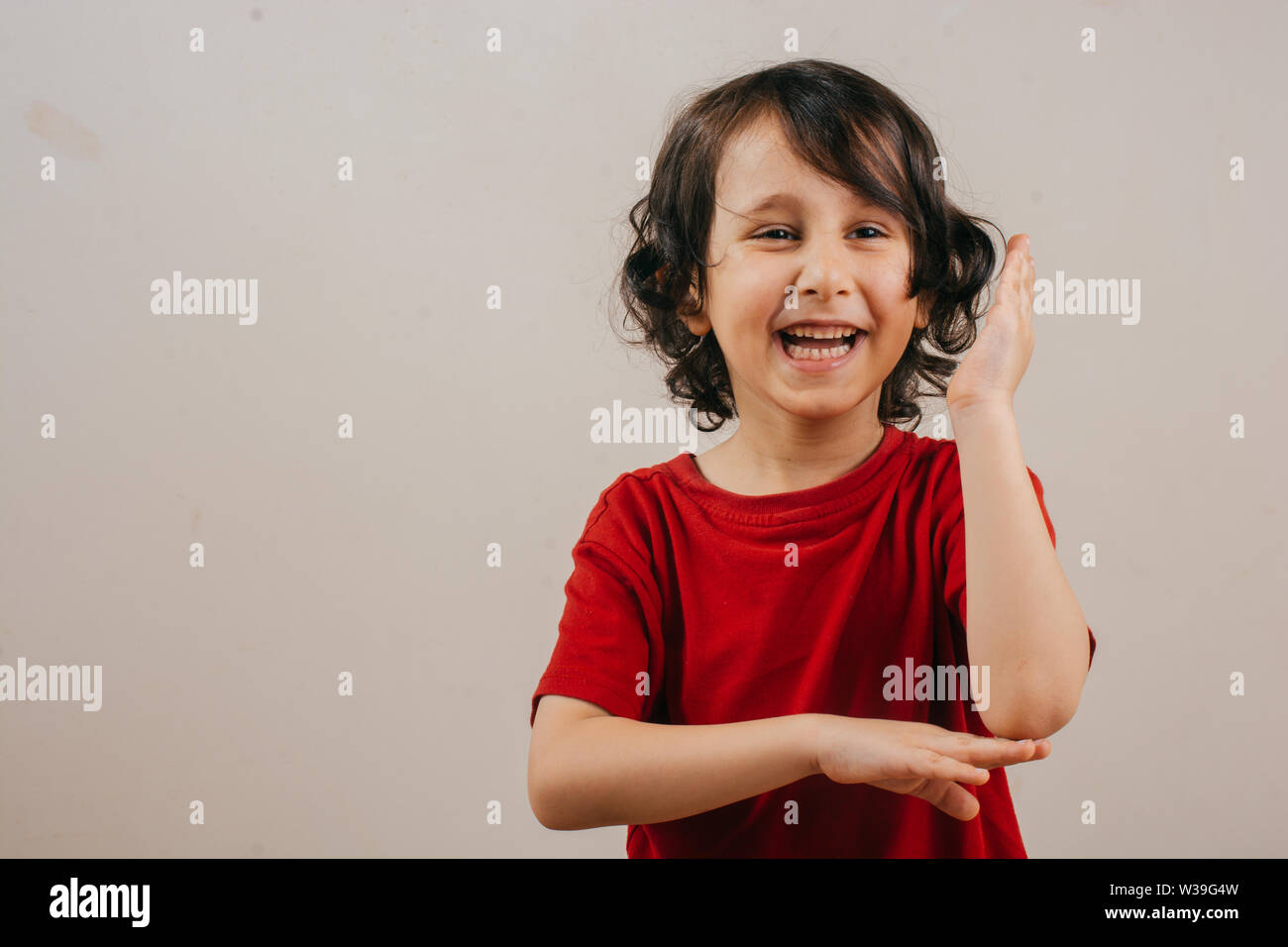 Smiling Little boy raising his hand isolated background Stock Photo - Alamy