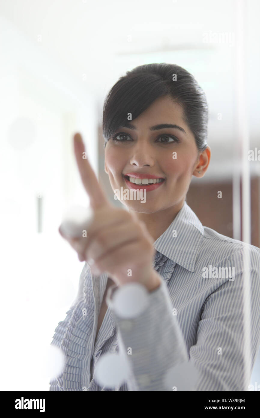 Businesswoman touching glass window and smiling Stock Photo - Alamy