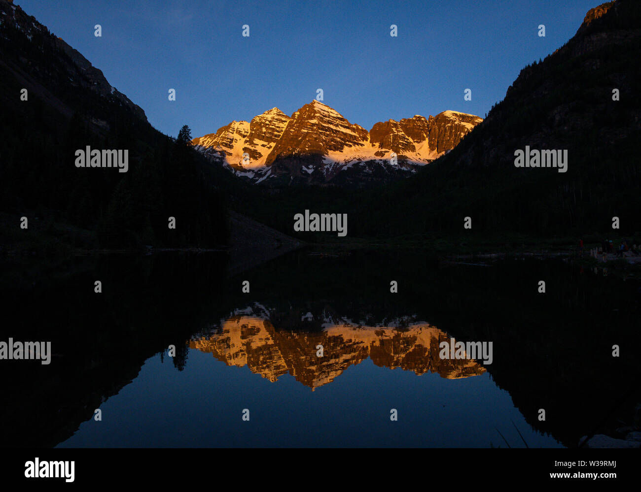 July 04, 2019: The sun lights up the Maroon Bells in the early morning ...