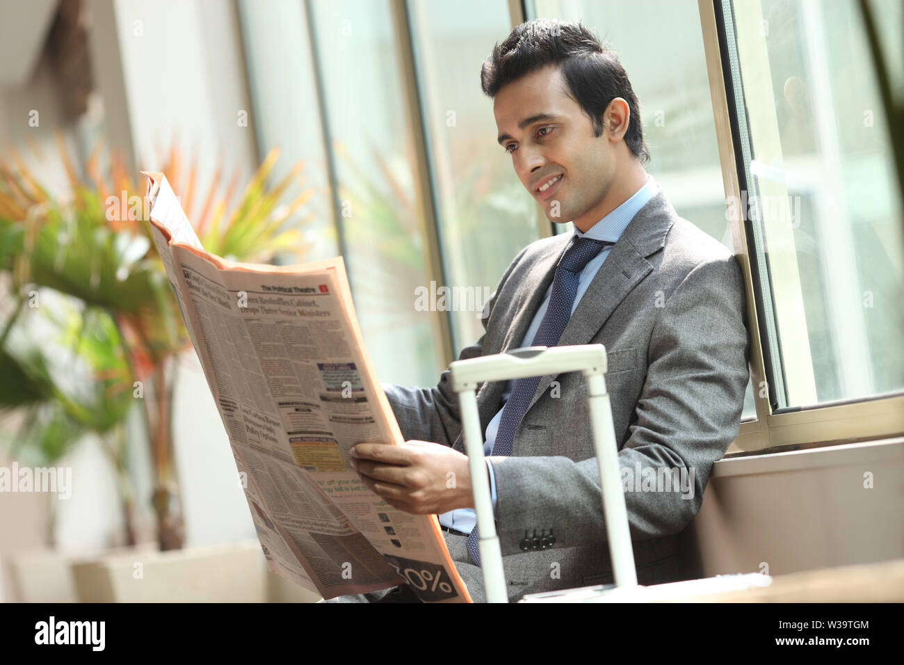 Businessman reading a newspaper Stock Photo - Alamy