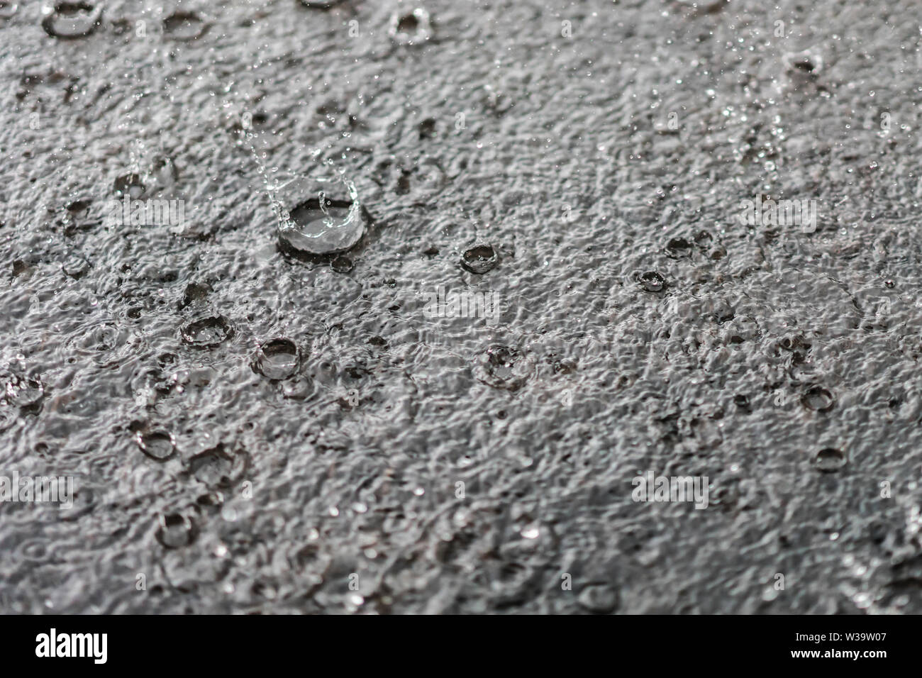 rain gray background. Drops on a puddle Stock Photo - Alamy