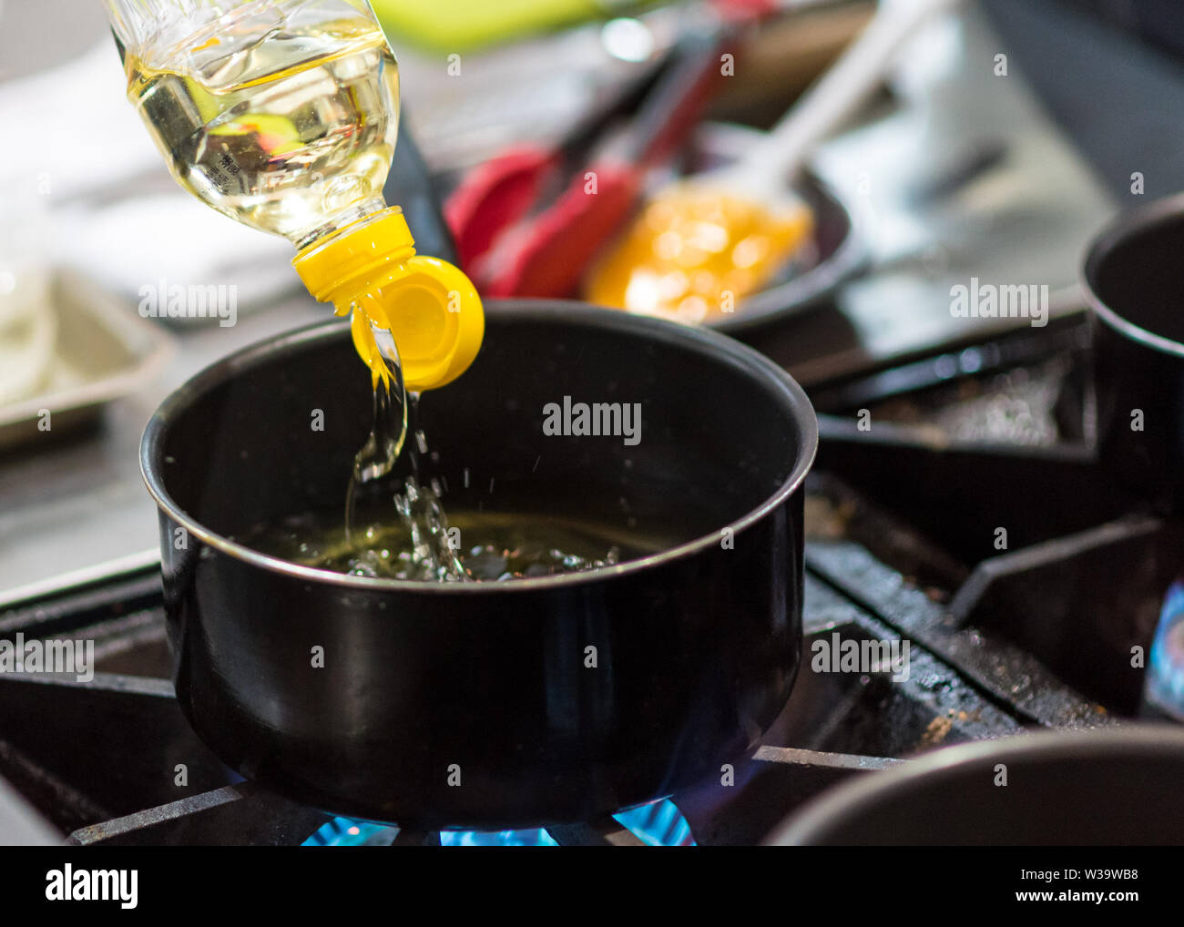 Chef pouring oil in frying pan, Chef cooking food in the kitchen Stock ...