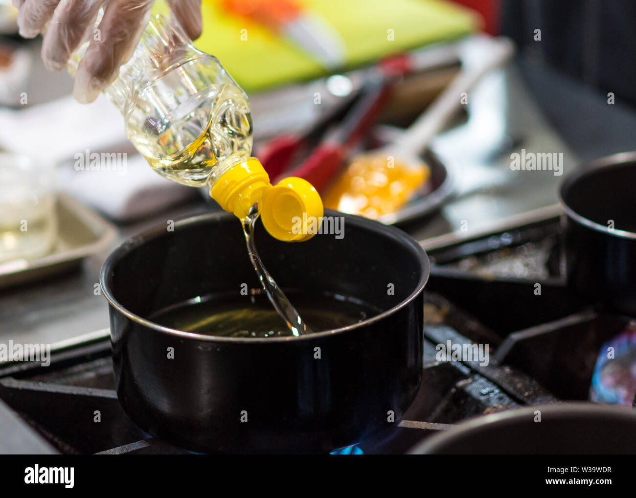 Chef pouring oil in frying pan, Chef cooking food in the kitchen Stock ...