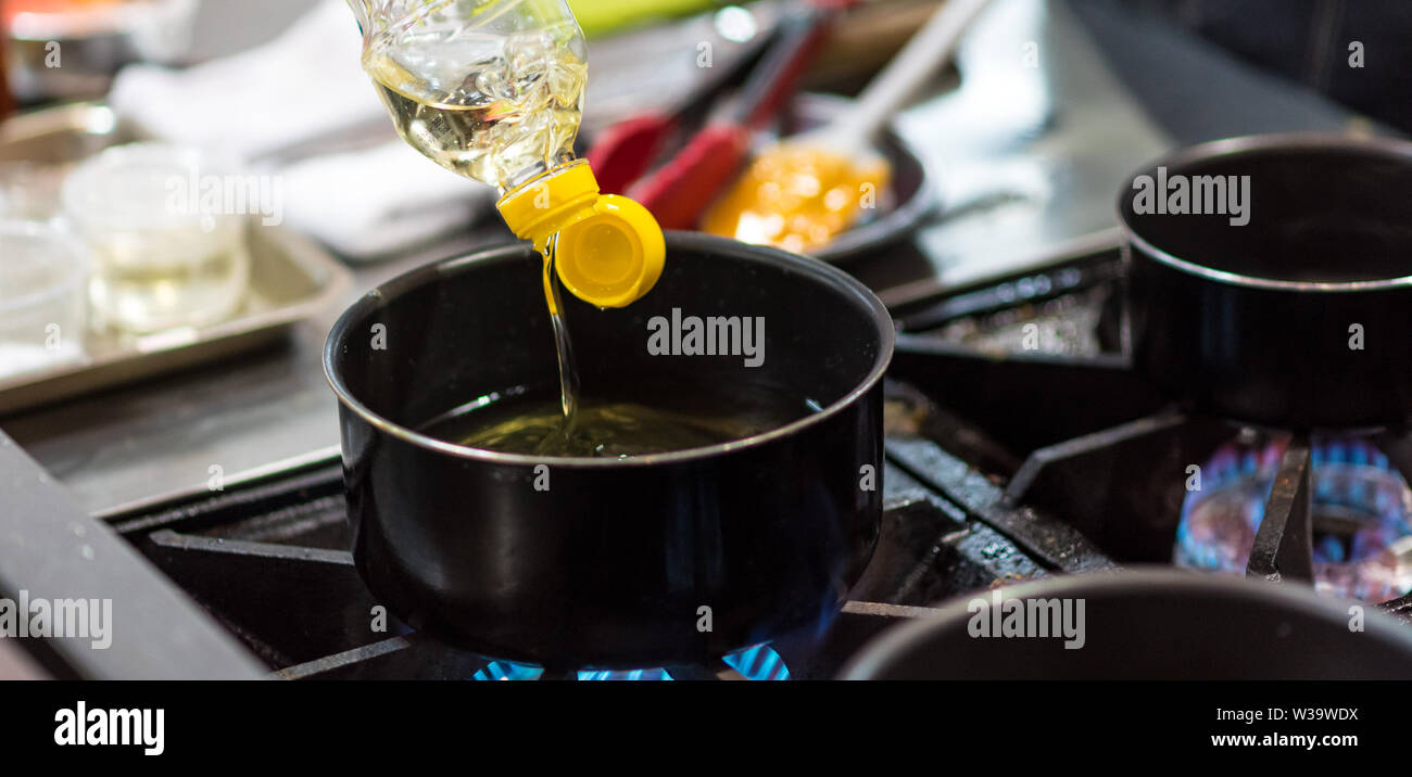 Chef pouring oil in frying pan, Chef cooking food in the kitchen Stock ...