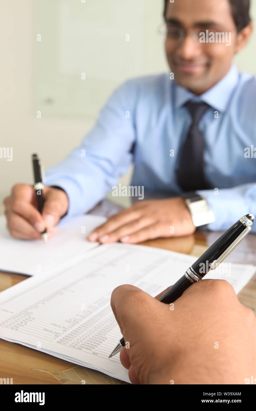 Two business executives signing contract Stock Photo - Alamy