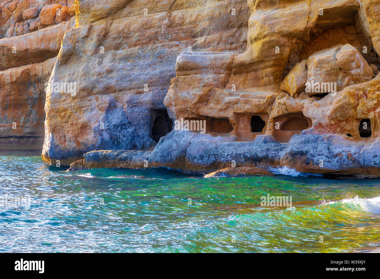 Matala beach cliff with caves, Crete island, Greece Stock Photo - Alamy
