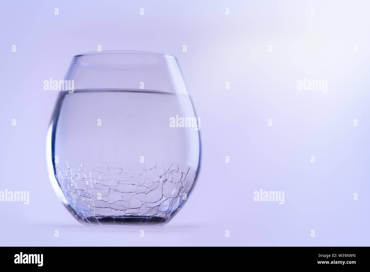 a glass of cold fresh water. A glass with a cracked glass, copy space ...