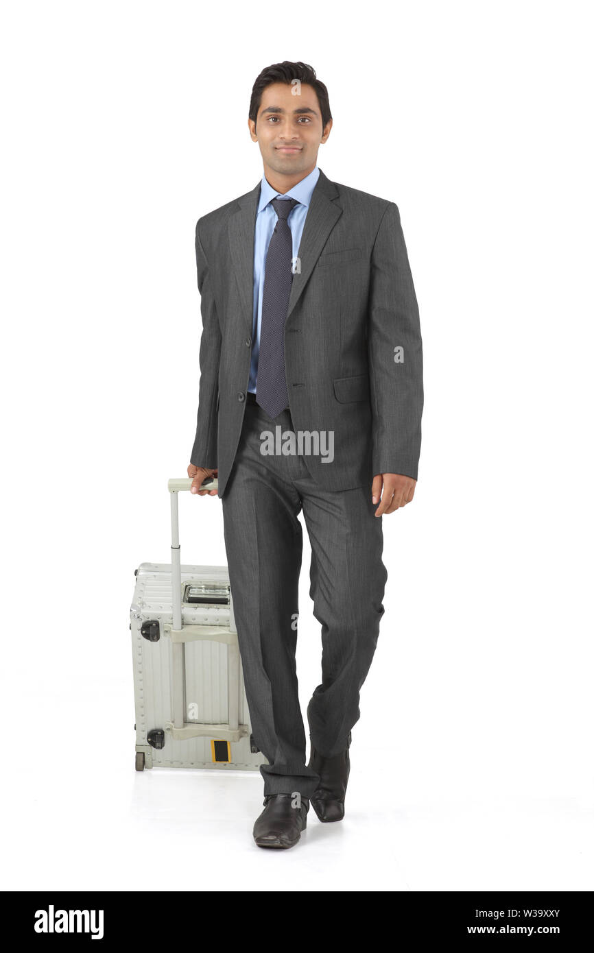 Businessman walking with suitcase Stock Photo - Alamy