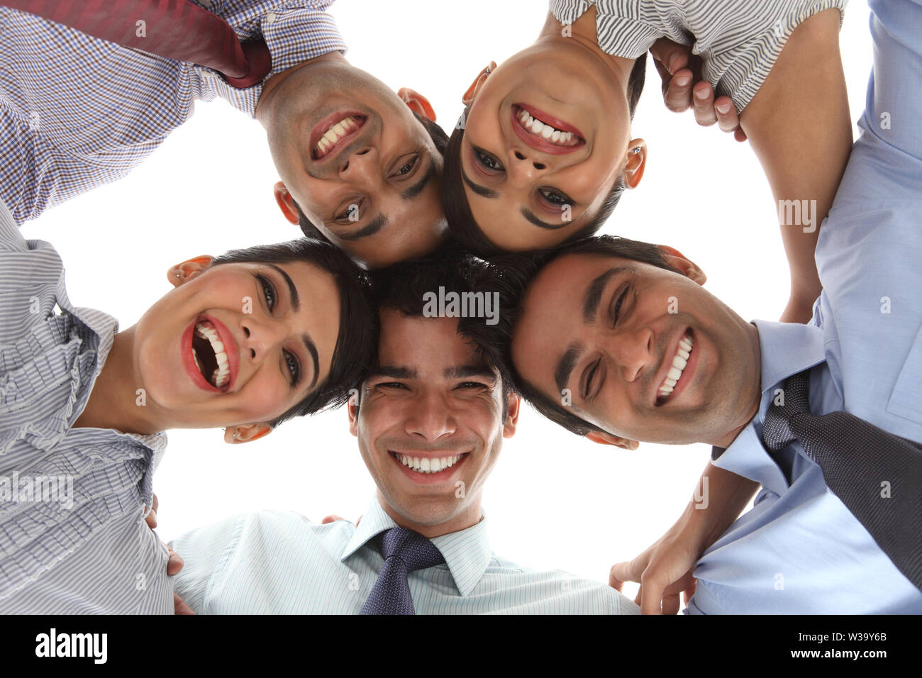 Group of business executives in a huddle and smiling Stock Photo - Alamy