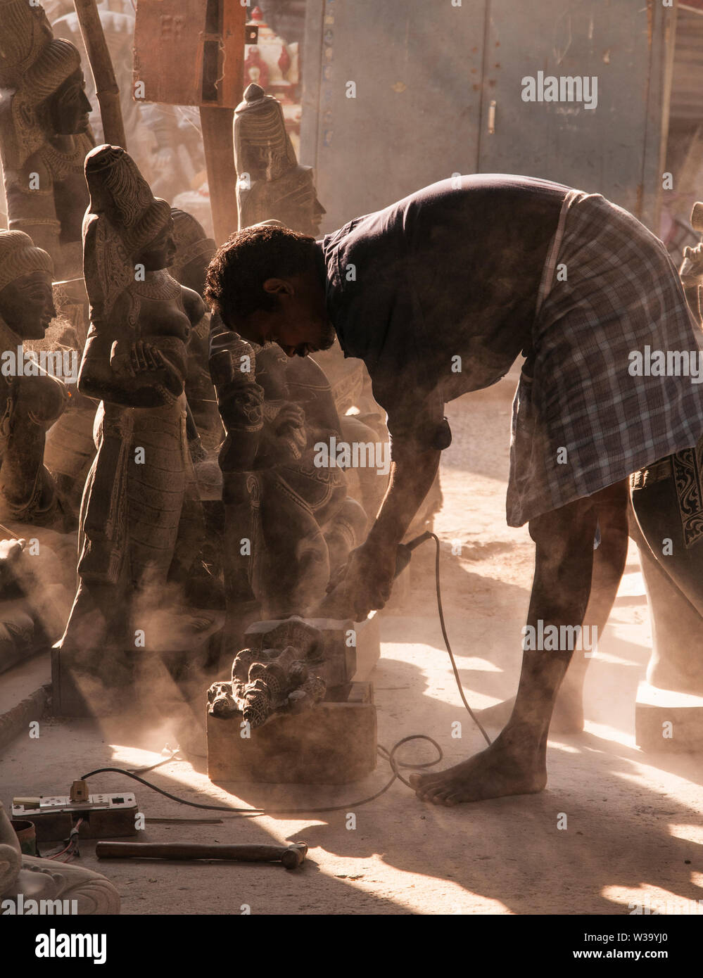 A sculptor sculpting a stone statue using a machine in Tamilnadu, South ...