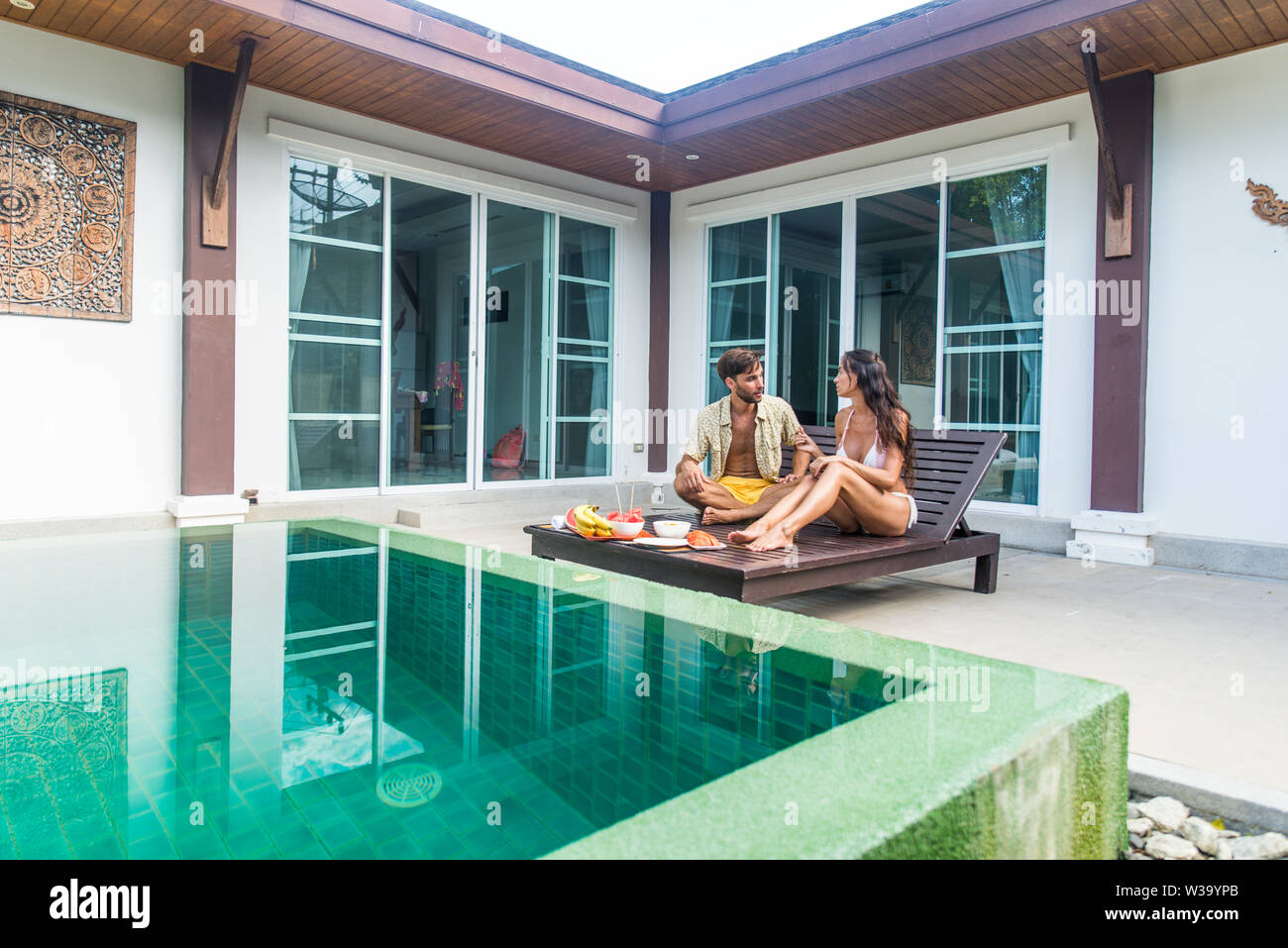Couple of lovers in a beautiful villa with swimming pool in a tropical climate location - Happy ...