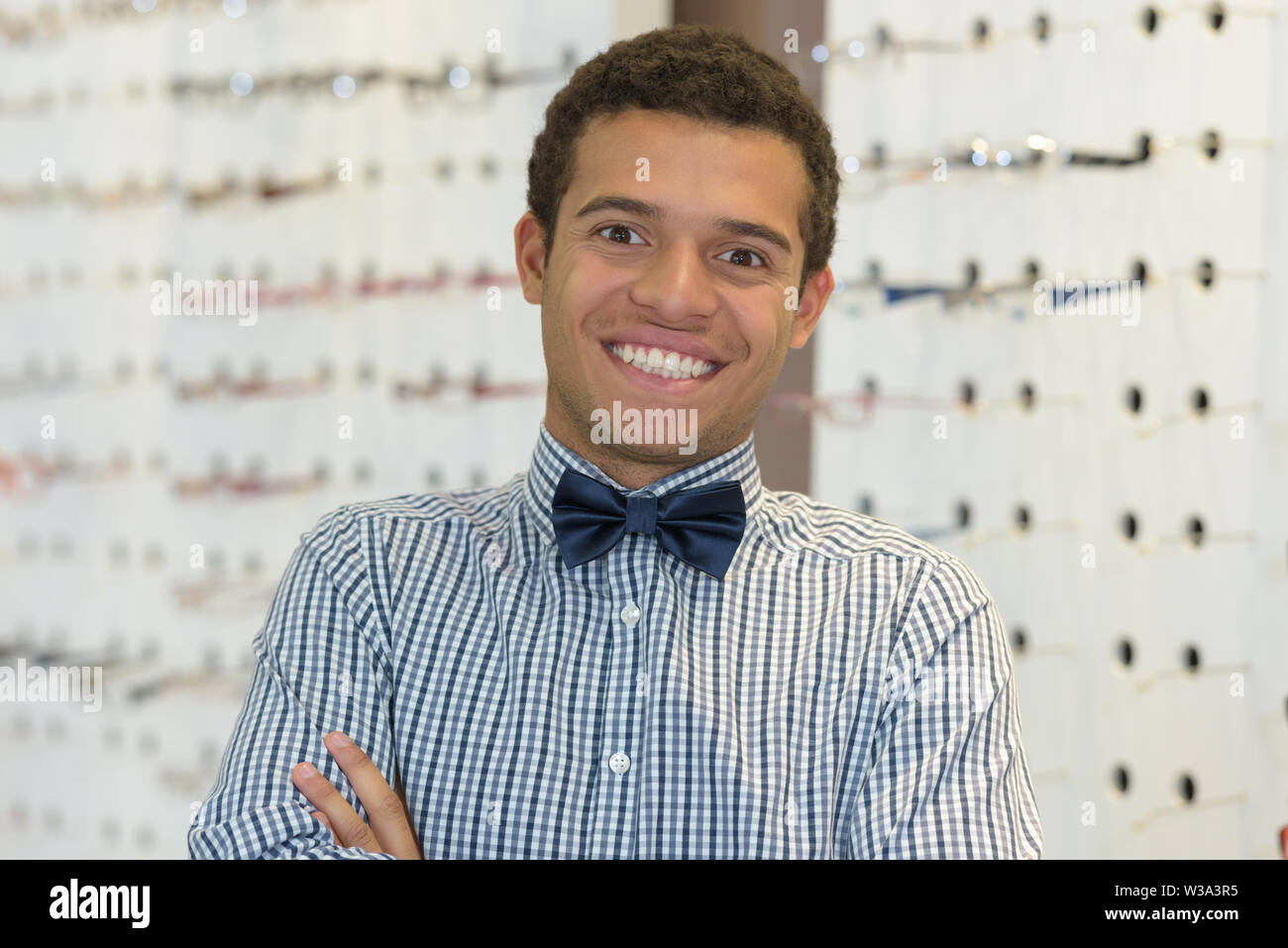 handsome young man choosing eyeglasses frame in optical store Stock ...