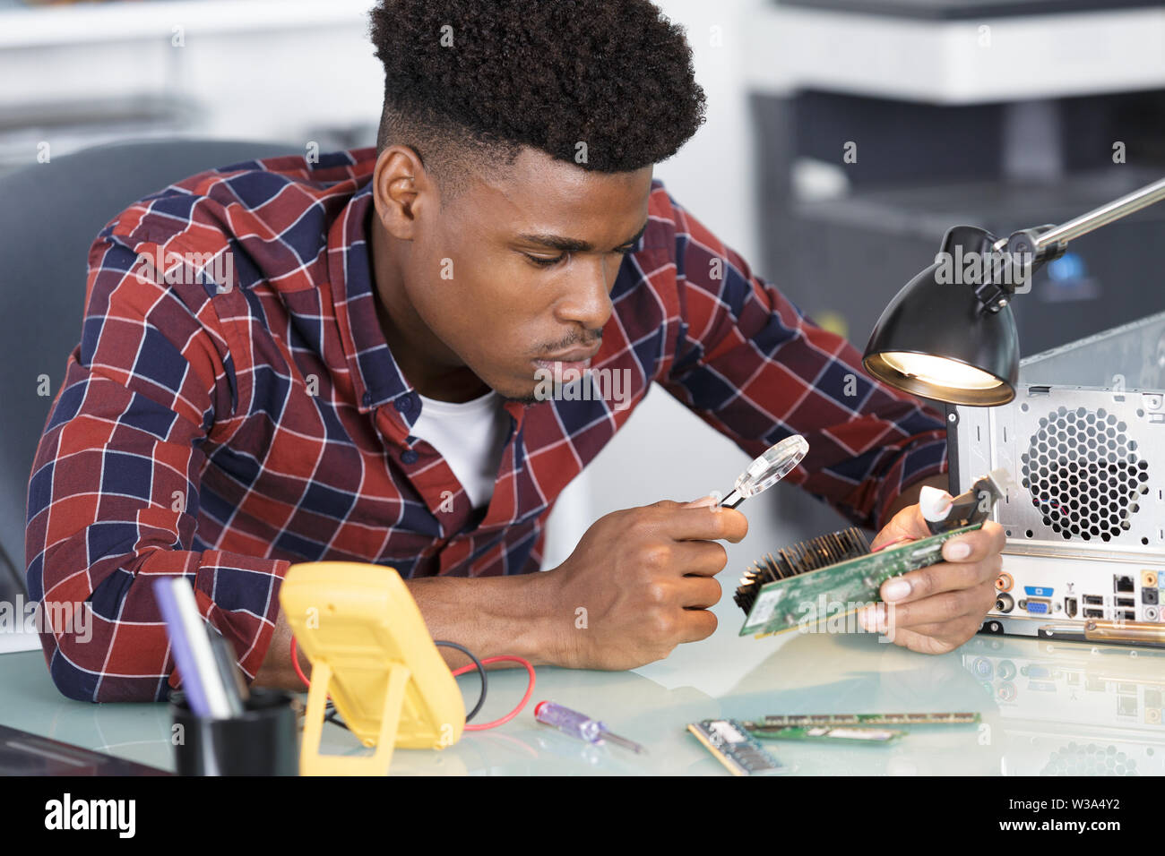 computer technician using magnifying glass Stock Photo - Alamy