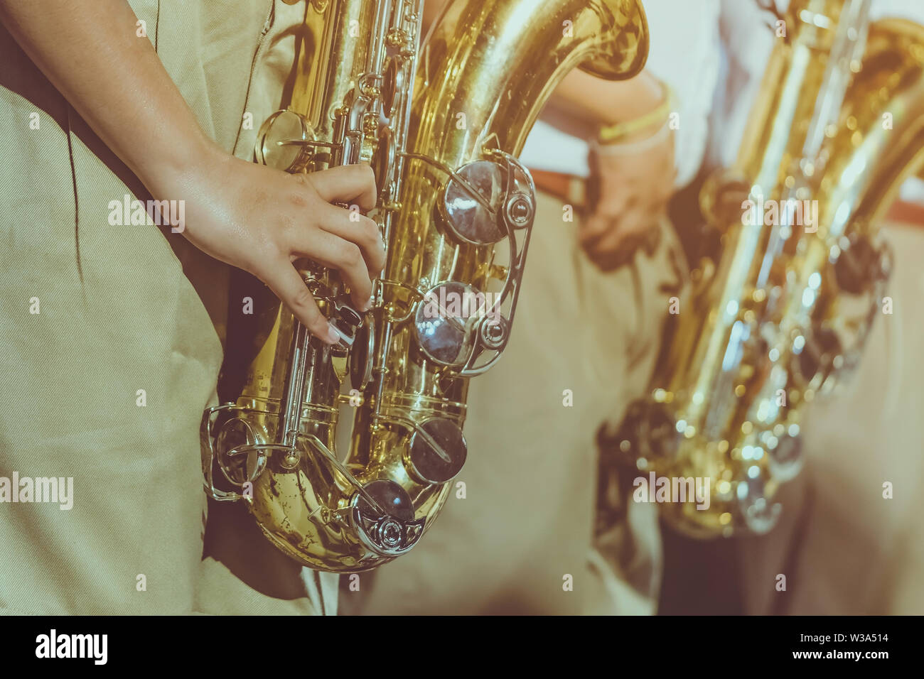 Male student with friends blow the saxophone with the band for ...