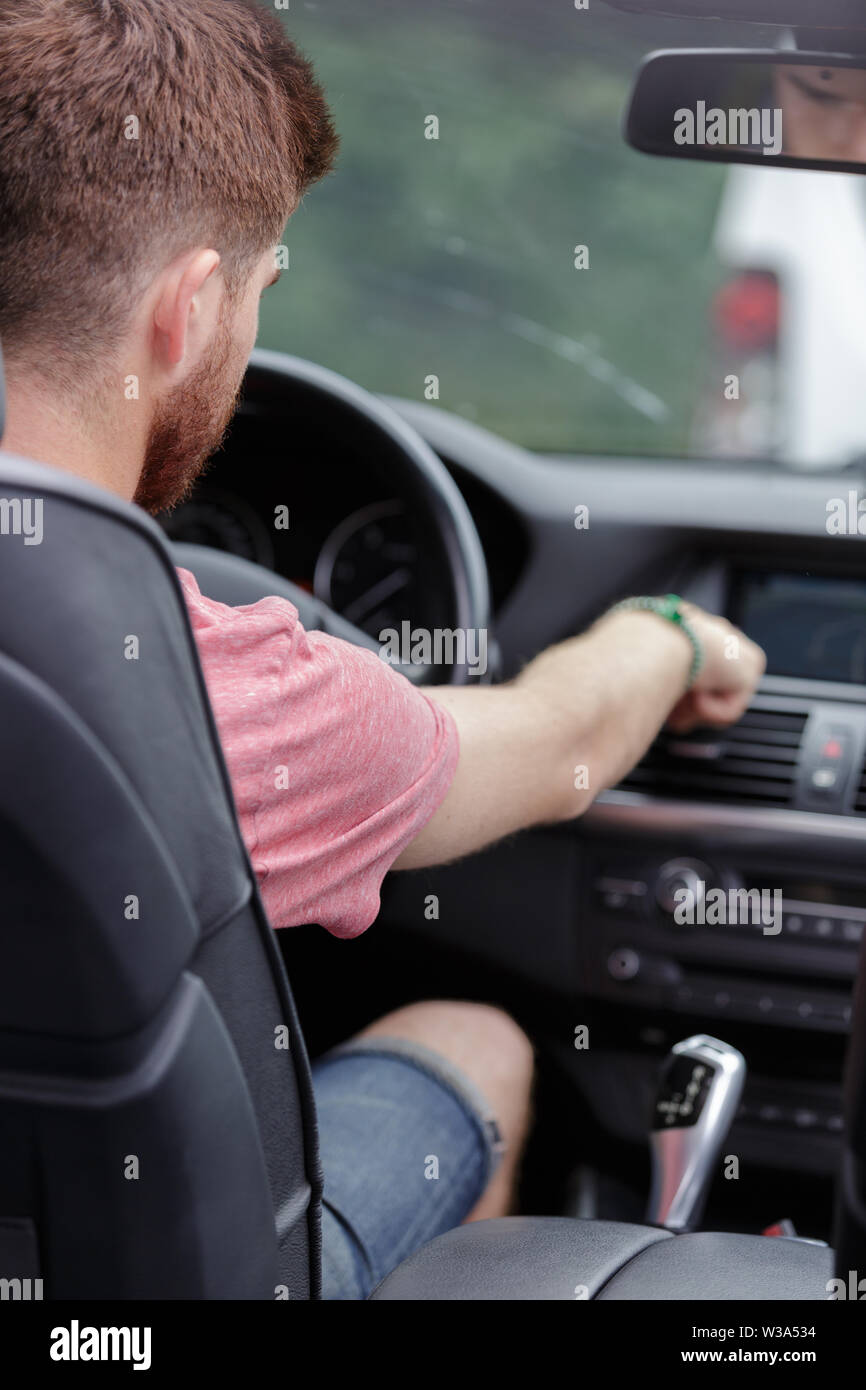man changing radio station while driving a car Stock Photo - Alamy