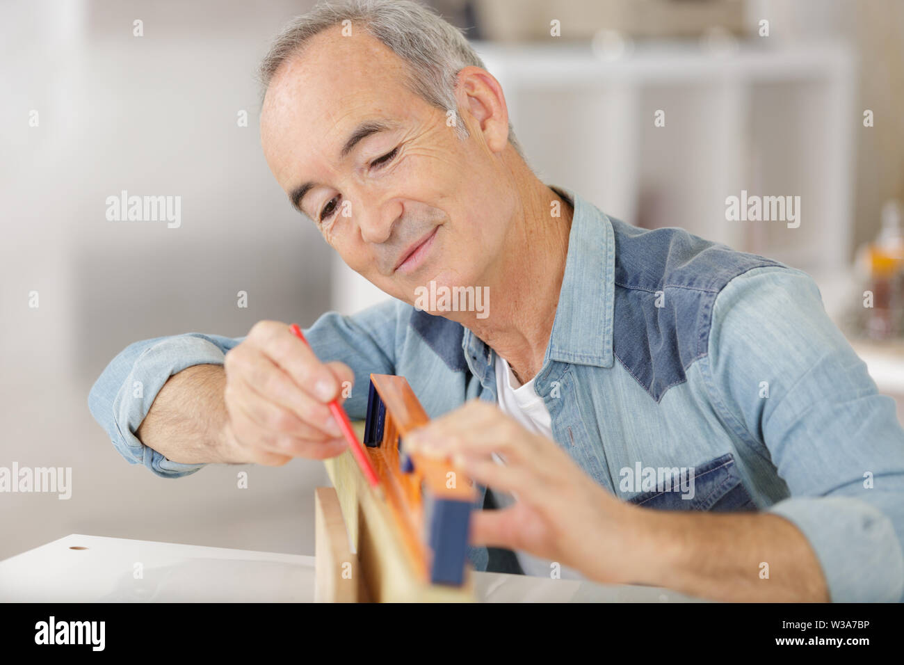 senior male carpenter using level on wood board Stock Photo - Alamy