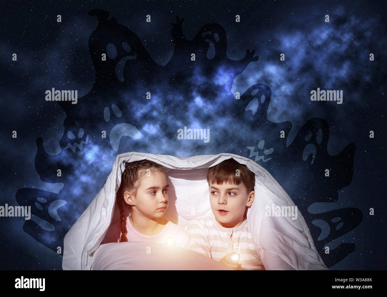 Scared sister and brother with flashlights Stock Photo - Alamy