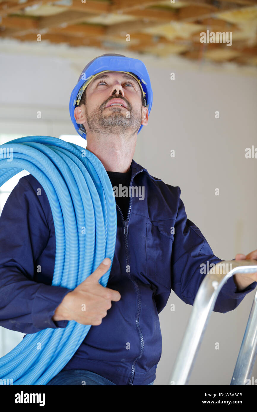 male builder holding a hose pipe insulation Stock Photo - Alamy