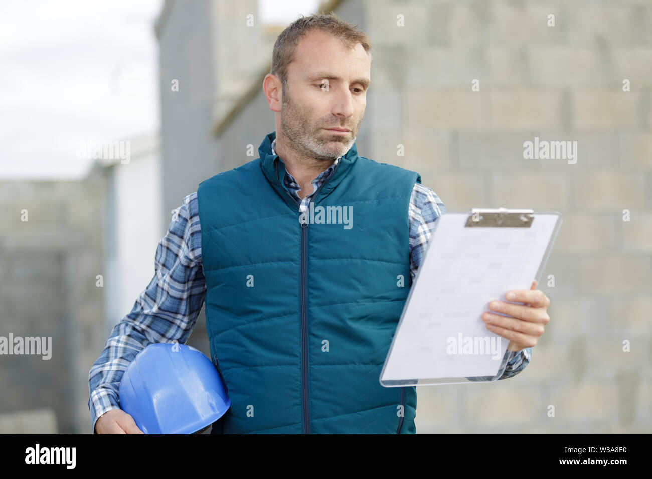 a builder is reading a clipboard Stock Photo - Alamy