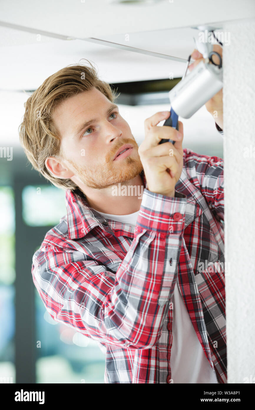 a young man installing cctv Stock Photo - Alamy