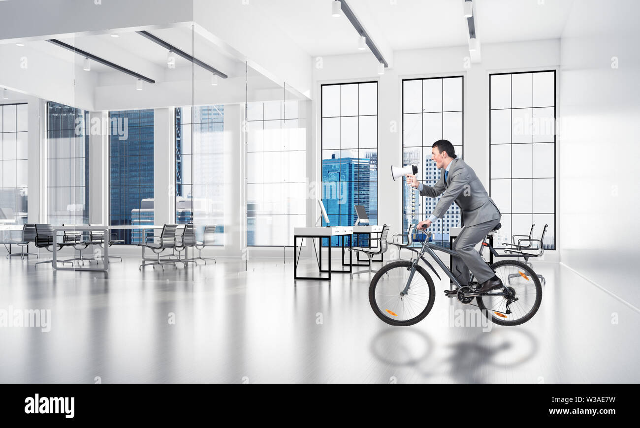 Manager riding bicycle at conference hall Stock Photo - Alamy