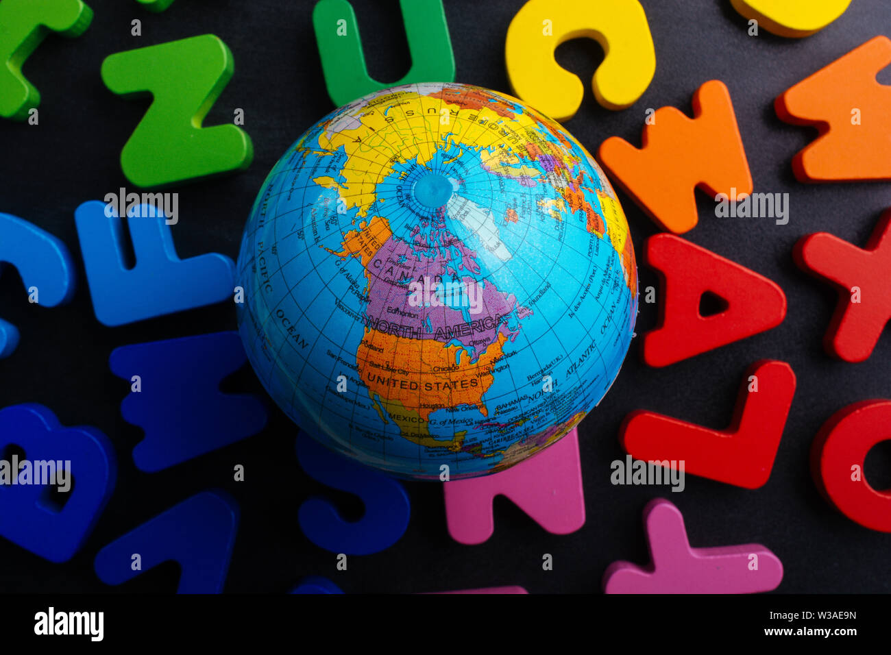 Earth globe model on colorful letters on a black background Stock Photo ...
