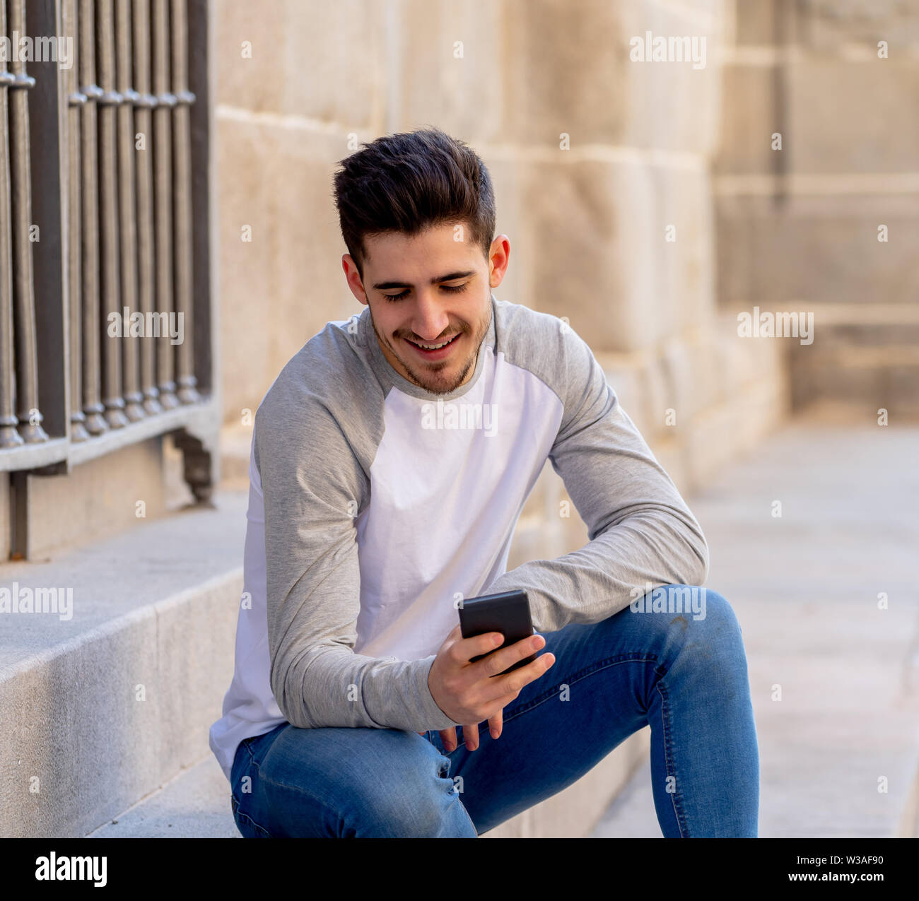 Happy student flirting and dating online and sending text message using ...