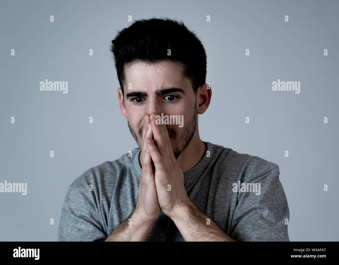 Close up portrait of handsome desperate young man suffering from ...