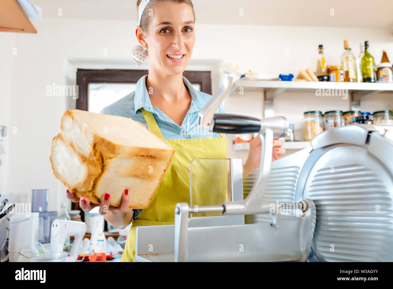 Happy woman cutting fresh bread hi-res stock photography and images - Alamy