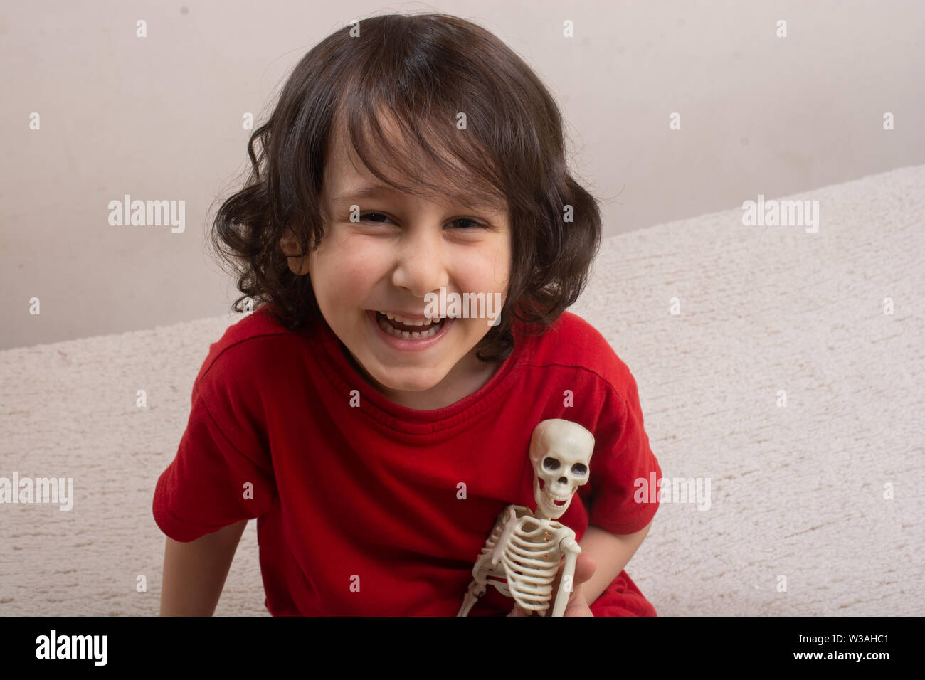 Little boy holding a small size artificial skeleton in hand Stock Photo ...