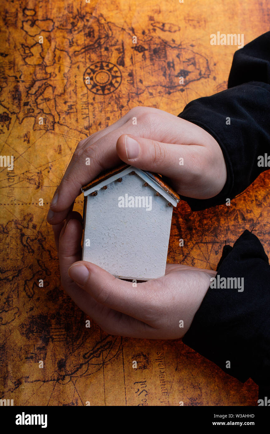 Model House on a vintage map background held by hands Stock Photo - Alamy