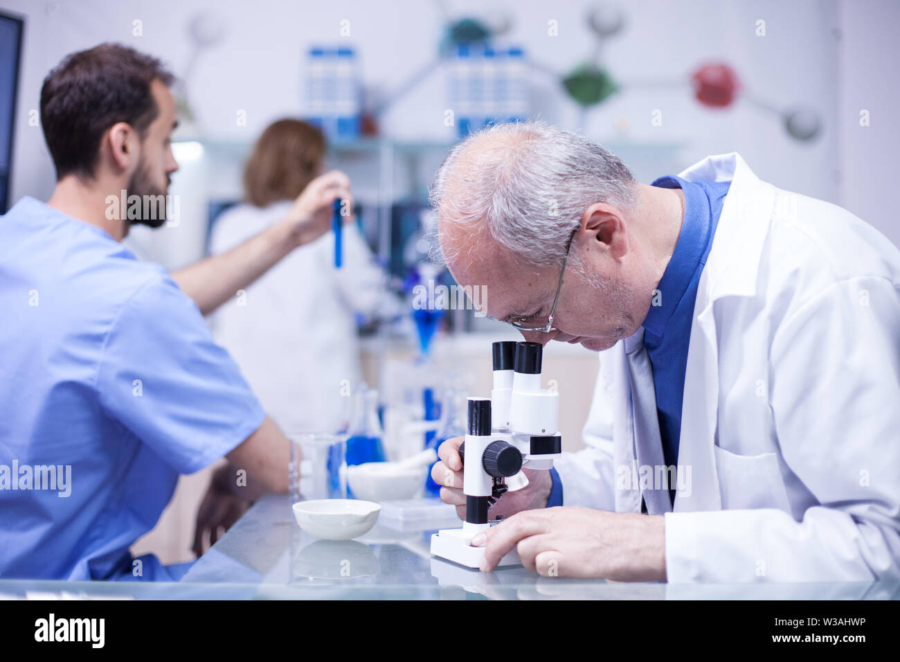 Senior technician making a discovery while working on microscope ...
