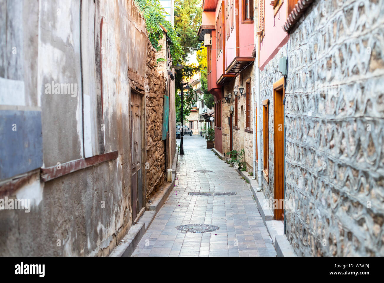 Narrow alley in the old town. Curved walls of houses in a narrow alley ...